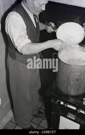 1950s, historical, making mead, a man in his basement putting the cork ...