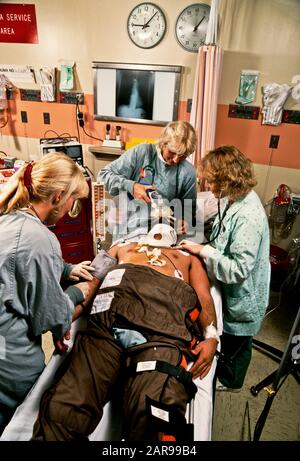 An emergency room trauma team treats an African American patient at a ...