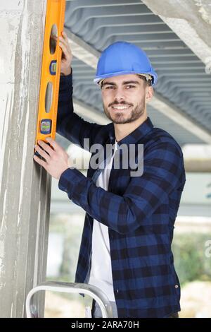 Worker uses level tool to smooth out wet concrete at home construction ...