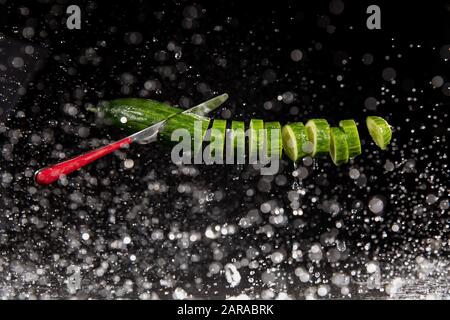 Sliced cucumber with splashing water or explosion flying in the air ...