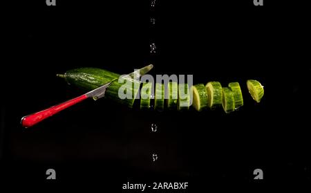 Sliced cucumber with splashing water or explosion flying in the air ...