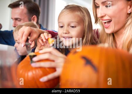 Happy family preparing for Halloween. Mother and child carving pumpkins ...