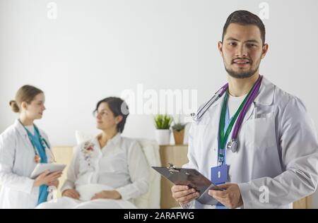 Patient with a group of doctors at the background Stock Photo - Alamy