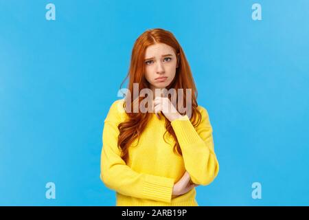 Upset and uneasy, sad cute redhead girl in yellow sweater, sulking ...