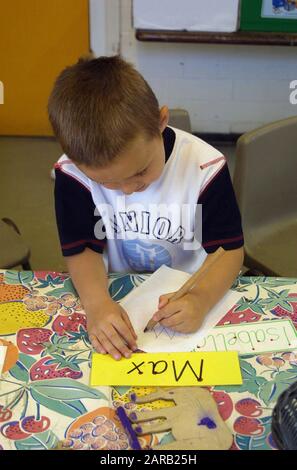 5 Year old boy writing his name on the blackboard in the kitchen Stock ...