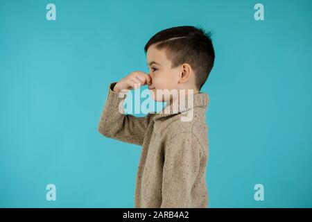 Kid gesture smells bad. Portrait of girl pinches nose with fingers ...