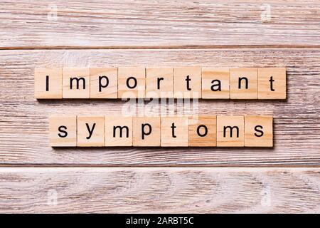 symptoms word written on wood block. symptoms text on table, concept ...