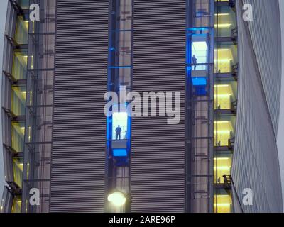 Moving outdoor glass elevators of a modern building Stock Photo - Alamy