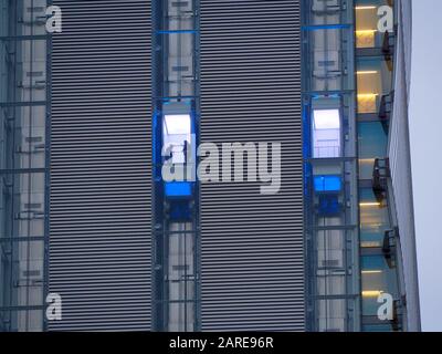Moving outdoor glass elevators of a modern building Stock Photo - Alamy