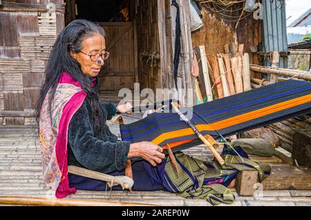 Apatani woman weaving material at a traditional hand loom, Hani ...
