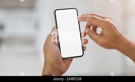 Cropped shot of a man using blank screen smartphone while working in ...
