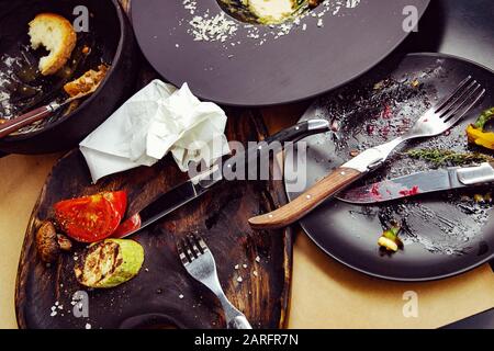 Messy table after party. Leftover food, spilled drinks, dirty dishes ...
