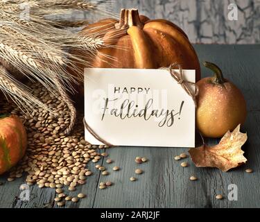 Happy Fallidays text with natural pumpkins and quince fruit. Flat lay ...