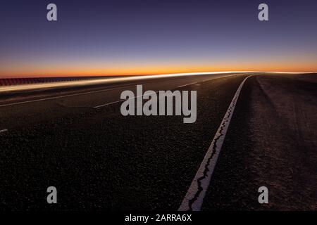 asphalt road running through the sandy desert at night Stock Photo - Alamy