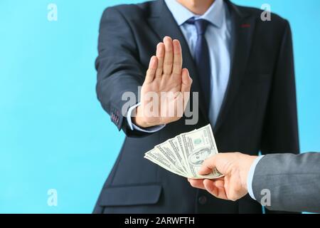 Businessman refusing to take bribe against light background, closeup ...