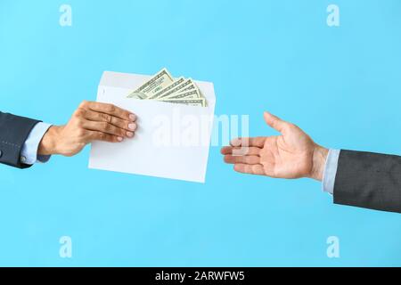 Businessman taking bribe against color background Stock Photo - Alamy