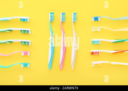 Different tooth brushes on color background Stock Photo - Alamy