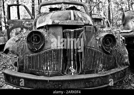 A weathered and rusting Studebaker antique car sitting along the old ...