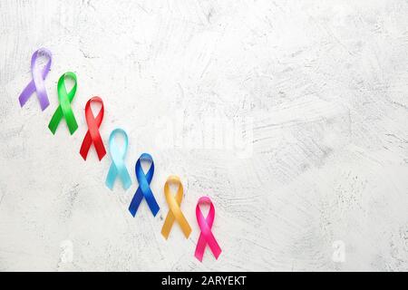 Different awareness ribbons on light background. National Cancer ...