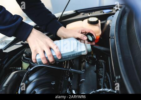 Male mechanic refilling car oil in service center Stock Photo - Alamy