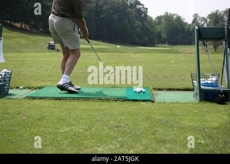 summer day with man hiting a golf ball at the driving range Stock Photo ...