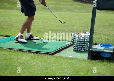 summer day with man hiting a golf ball at the driving range Stock Photo ...