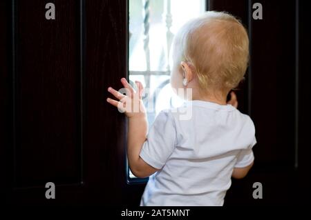 little girl waiting near the front door of mom and dad. Back view Stock ...