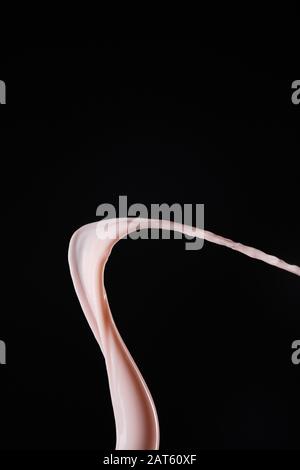 smooth fresh pink milk splash isolated on black Stock Photo - Alamy