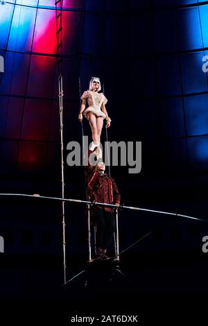handsome gymnast supporting attractive acrobat while holding pole Stock ...