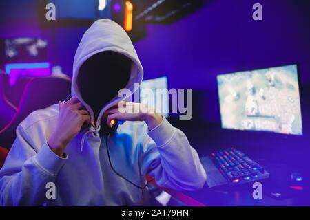 Female cyber hacker gamer in headphone confused while playing games or ...