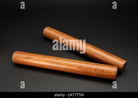 Closeup of a pair of wooden claves lying on a black underground Stock ...