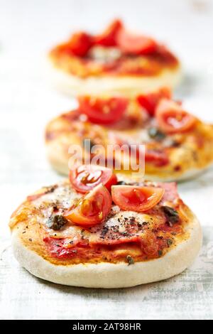 Mini pizzas with ham on wooden table Stock Photo - Alamy