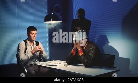 Police detective questioning suspect black man in interrogation room ...