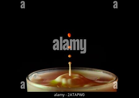 cream dropping in to a class Stock Photo - Alamy