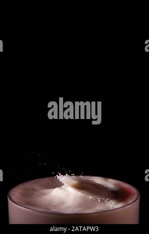 cream dropping in to a class Stock Photo - Alamy