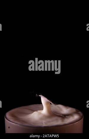cream dropping in to a class Stock Photo - Alamy
