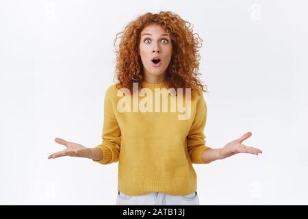 Amazed redhead girl in sweater, showing thumbs up and praising product ...