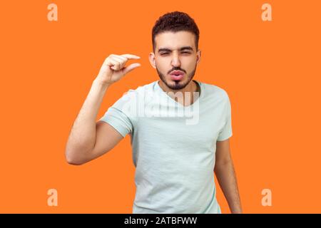 Displeased and disappointed man in orange sweater, grimacing and ...