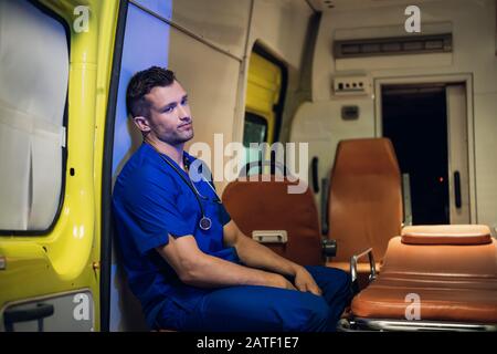 Tired corpsman in medical uniform sits inside the ambulance car Stock ...