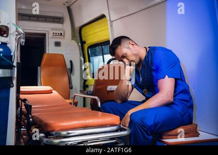 Tired corpsman in blue uniform sits inside the ambulance car Stock ...