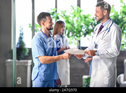 Doctors discussing something in hall of clinic Stock Photo - Alamy