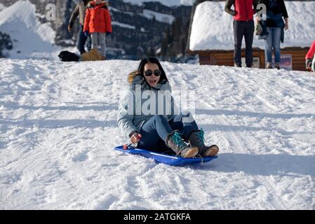 Woman on a sledge, scared Stock Photo - Alamy