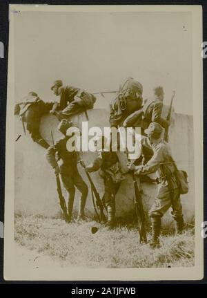 Soldiers climb over a wall Date: 1946 Location: Indonesia Dutch East ...