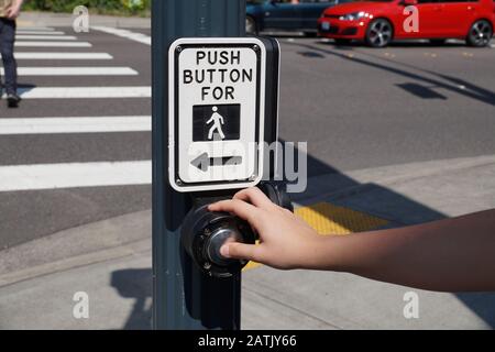 Pedestrian pressing push button on pedestrian crossing Stock Photo - Alamy
