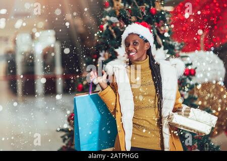Winter holidays and shopping concept. Cheerful african american man in ...