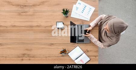 Unrecognizable Muslim businesswoman sitting at table in front of her ...