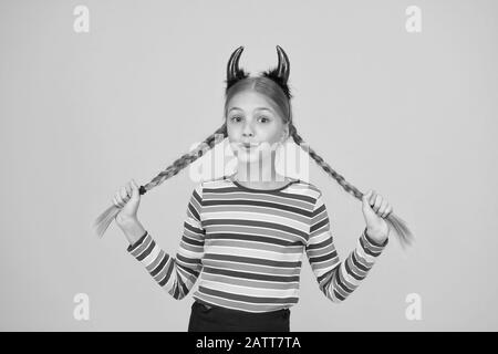 small child with red horns of demon and adult scary man standing in ...