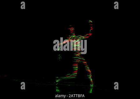 Laser beams silhouette of a dancer performing a contemporary dance ...