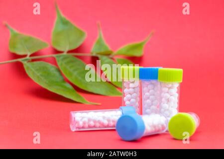 Homeopathic lactose sugar globules in glass bottles with plants Stock ...