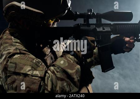 Side view of old military officer holding sniper rifle and aiming ...